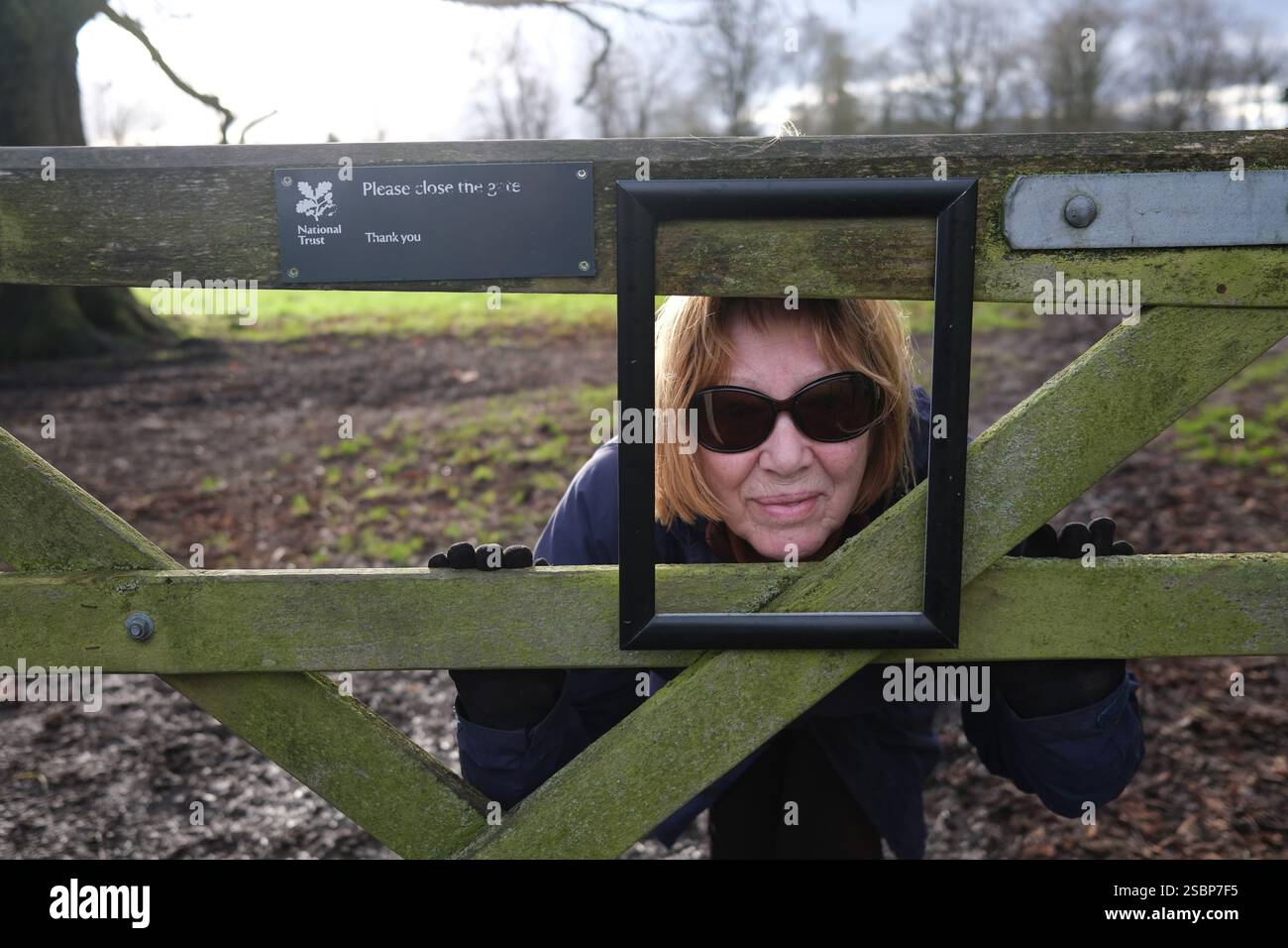 In the frame woman posing through empty frame on National Trust gateway ...