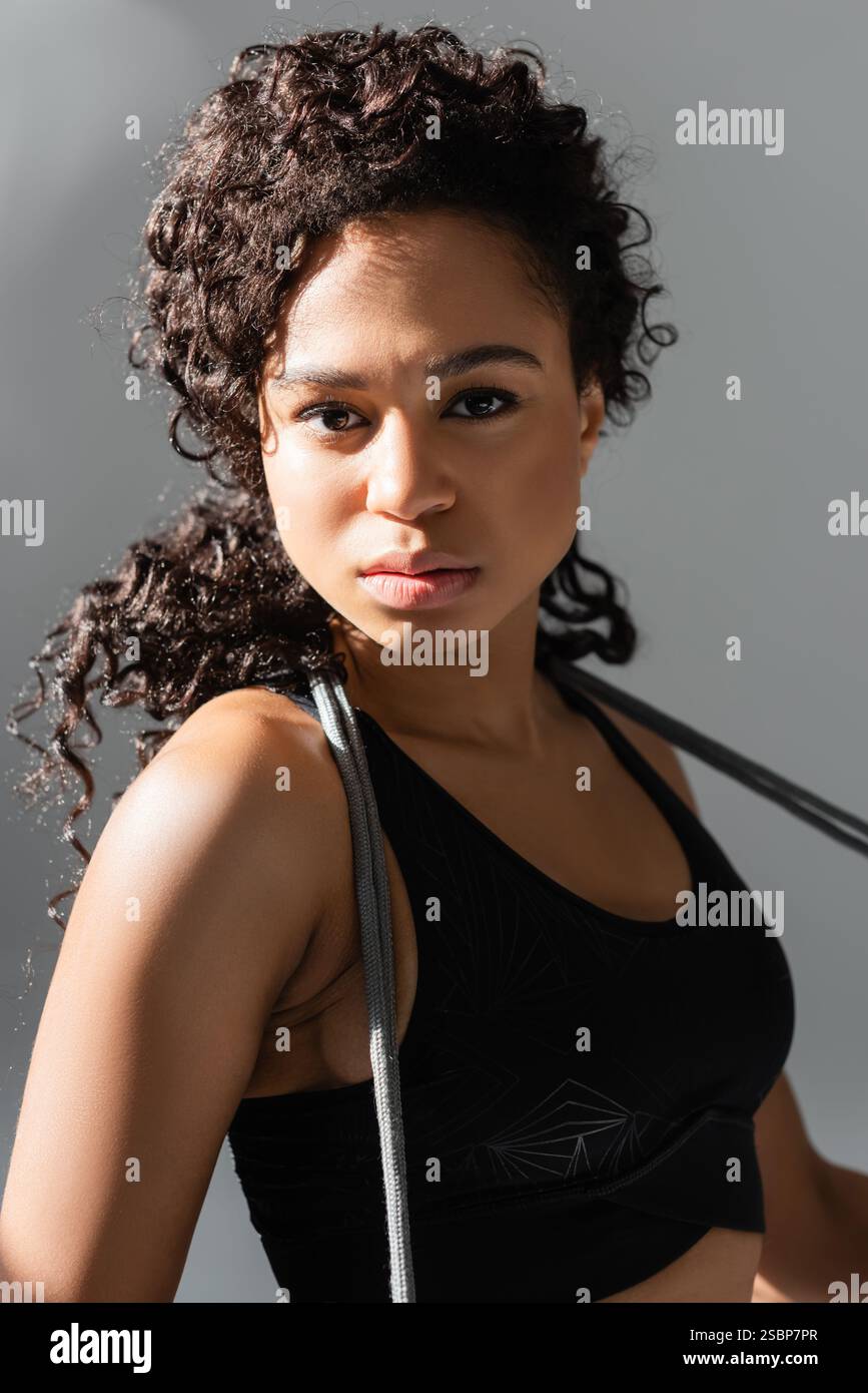 Strong female athlete confidently poses in sportswear, highlighting ...