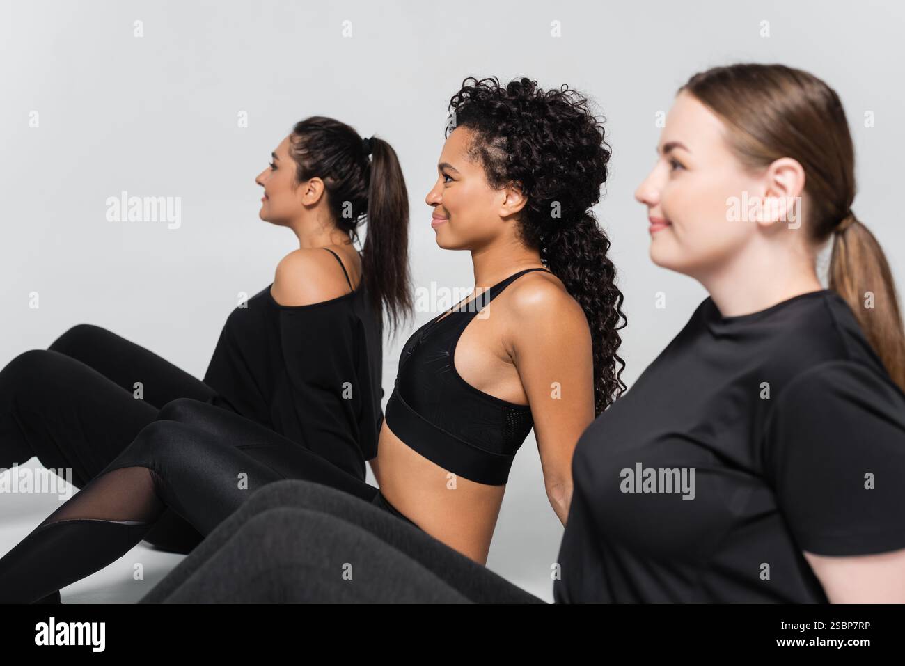 Three strong women in coordinated athletic wear showcase their strength ...