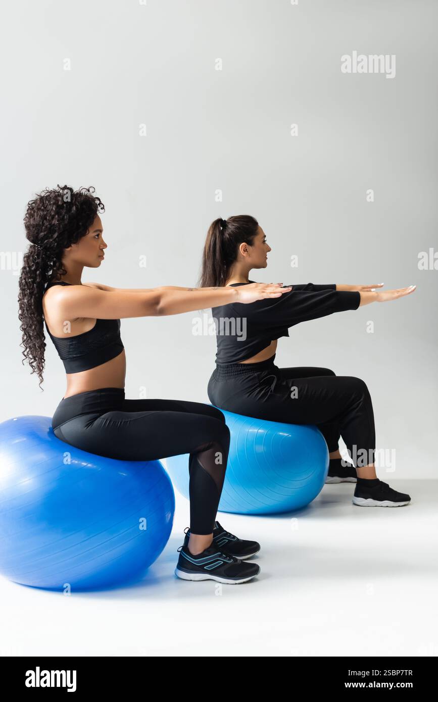 Two strong women practice exercises on stability balls, enhancing their ...