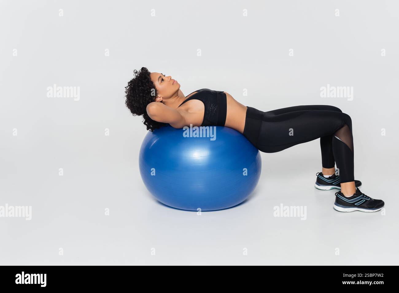 Strong woman engages in a fitness routine using a stability ball in a ...