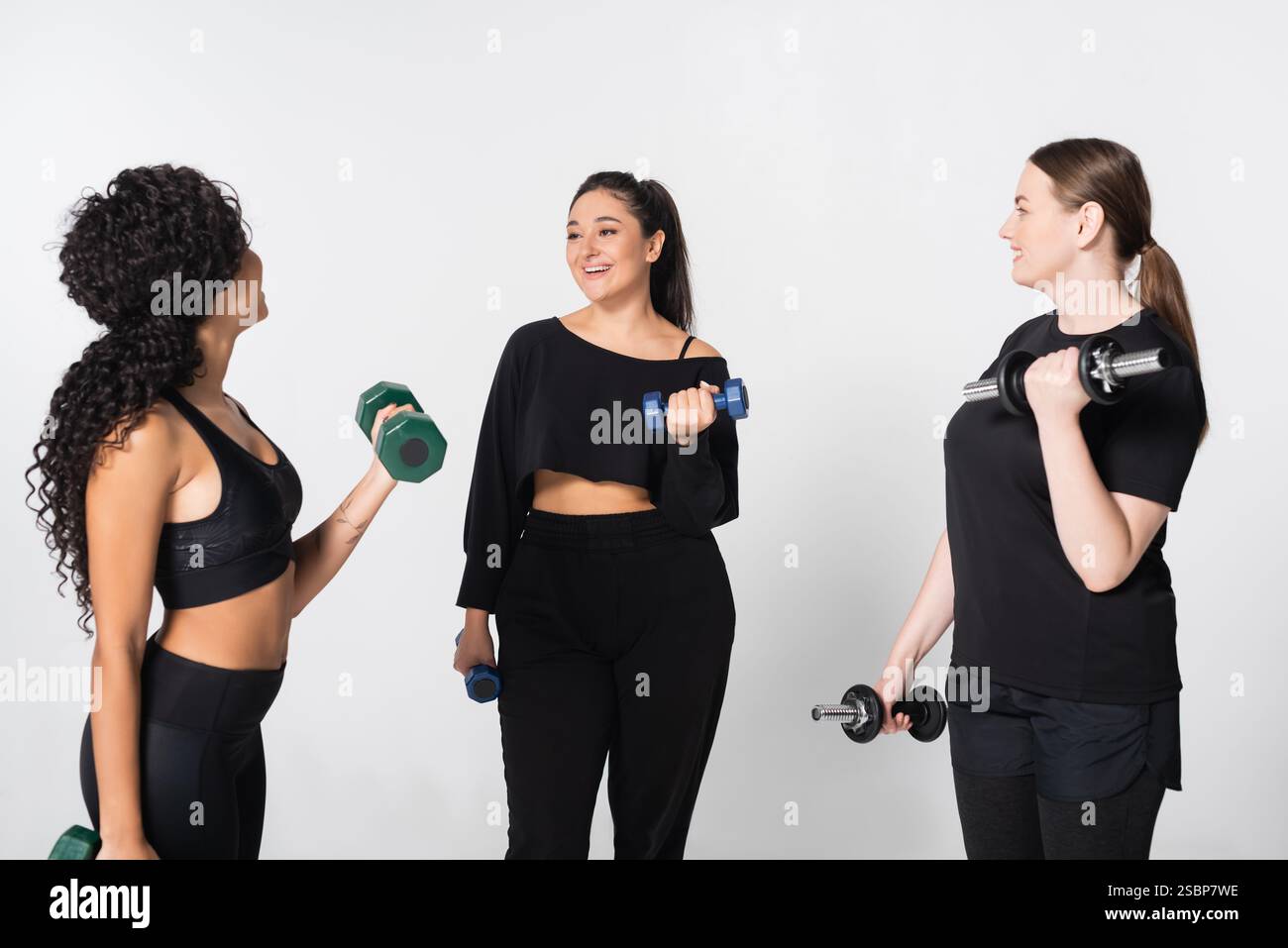 Three strong women share fitness tips while lifting weights, building a ...