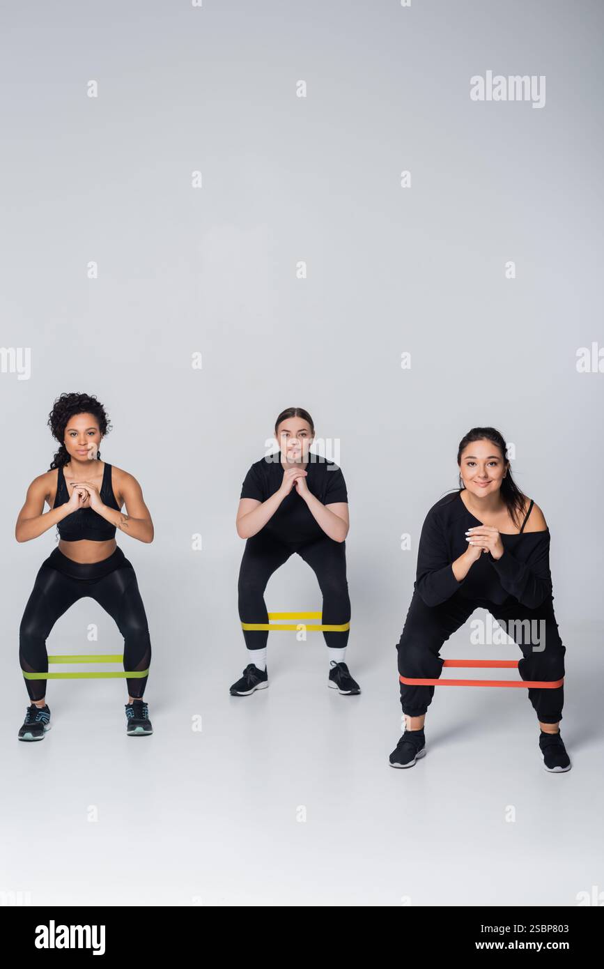 Three women engage in leg exercises using resistance bands, showcasing ...