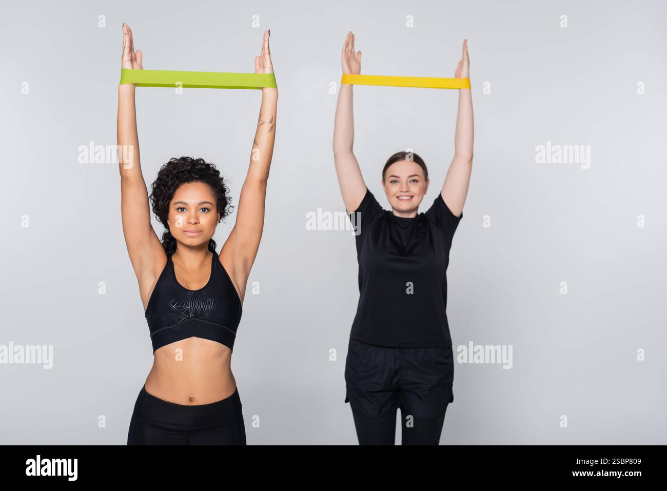 Two fit women showcase strength through resistance band exercises in a ...