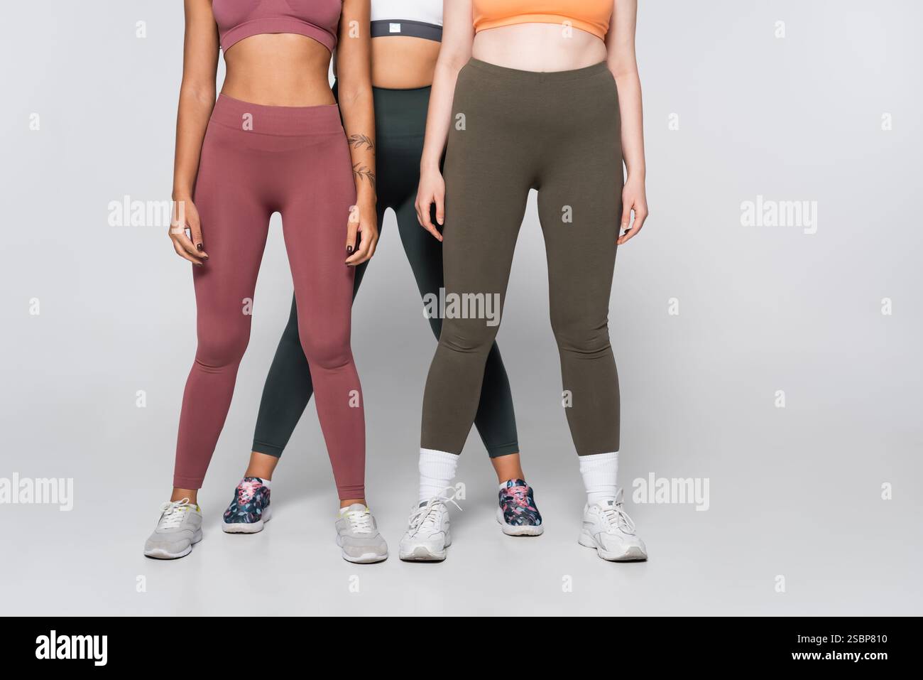 Three fit women pose in colorful workout attire, embodying confidence ...