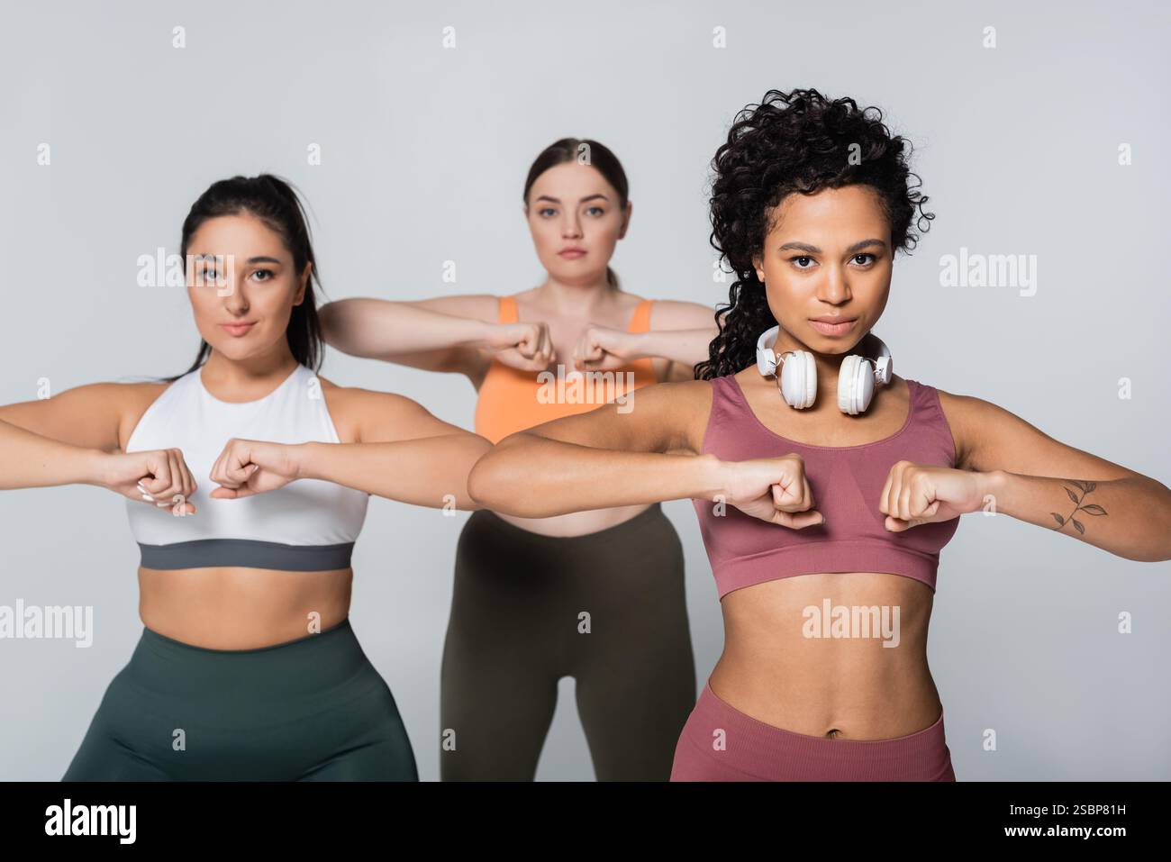 Three strong women engage in a dynamic fitness routine, embodying strength and confidence ...