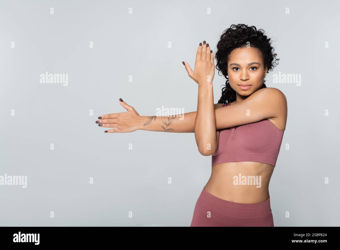 A confident woman showcases strength and grace in a dynamic stretching ...