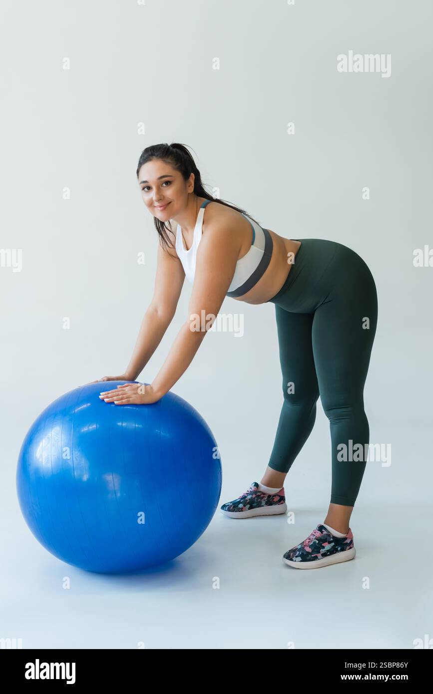 Fitness enthusiast enjoys a dynamic workout routine using a large blue ...
