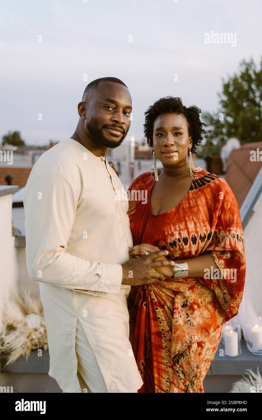 Portrait of newly married couple in traditional clothing standing on ...