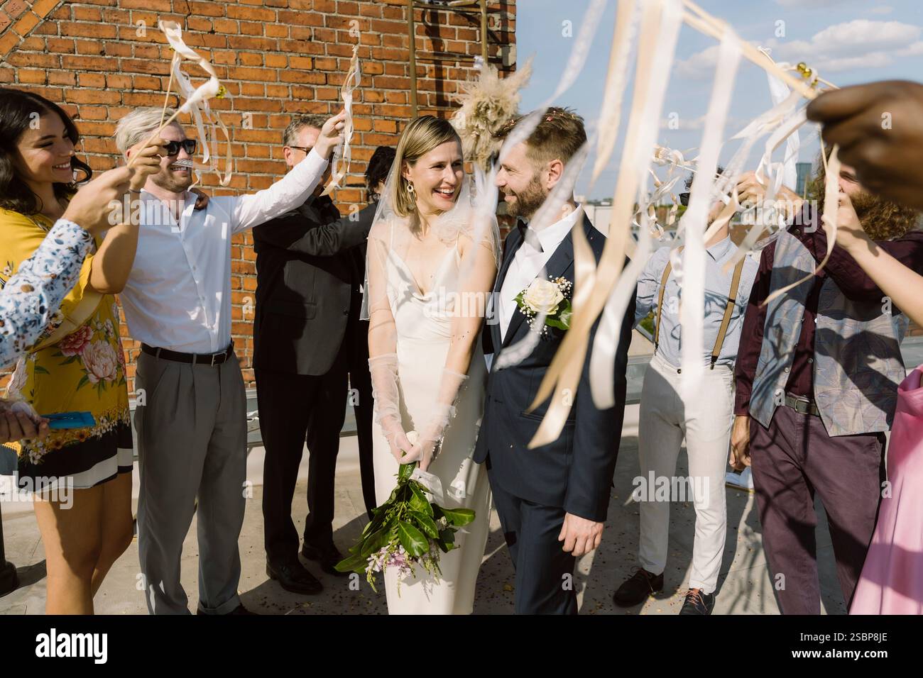 Happy guests cheering newlywed couple during wedding celebration on ...
