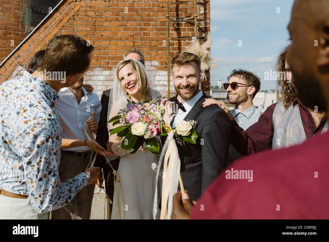 Happy guests congratulating newly married couple during celebration on ...