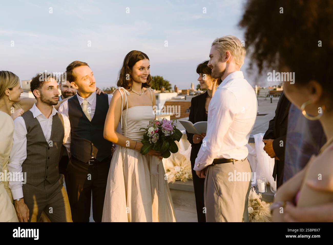 Smiling young couple exchanging vows at wedding ceremony on rooftop ...