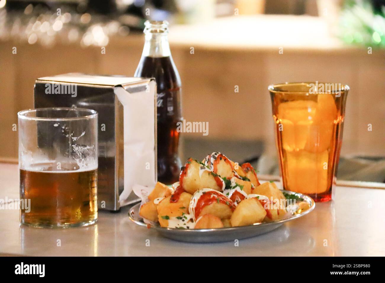Fresh beer, coke and Spanish tapa called Patatas Brava on a Spanish bar ...