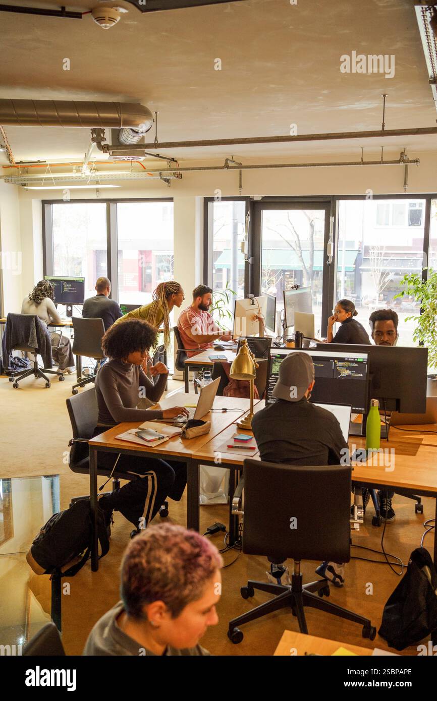Multiracial male and female computer programmers working in tech hub ...