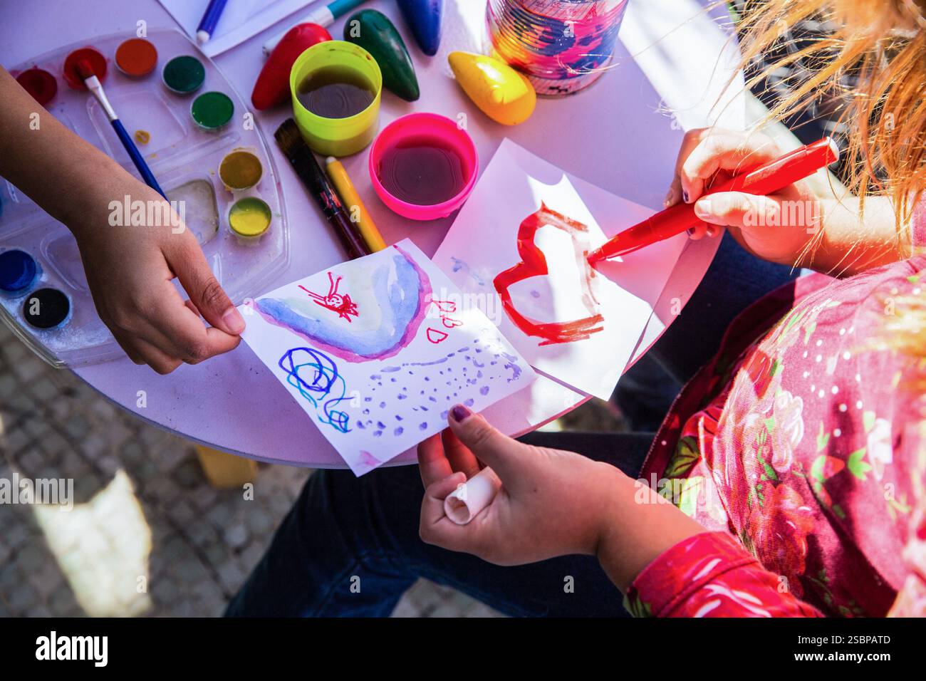 Two children are busy expressing their creativity by painting colorful ...