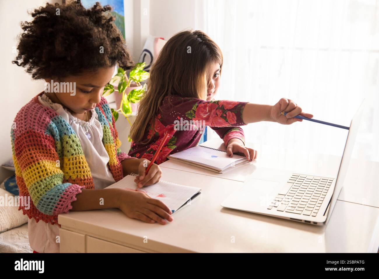 Two girls are focused on drawing and learning at a bright workspace ...