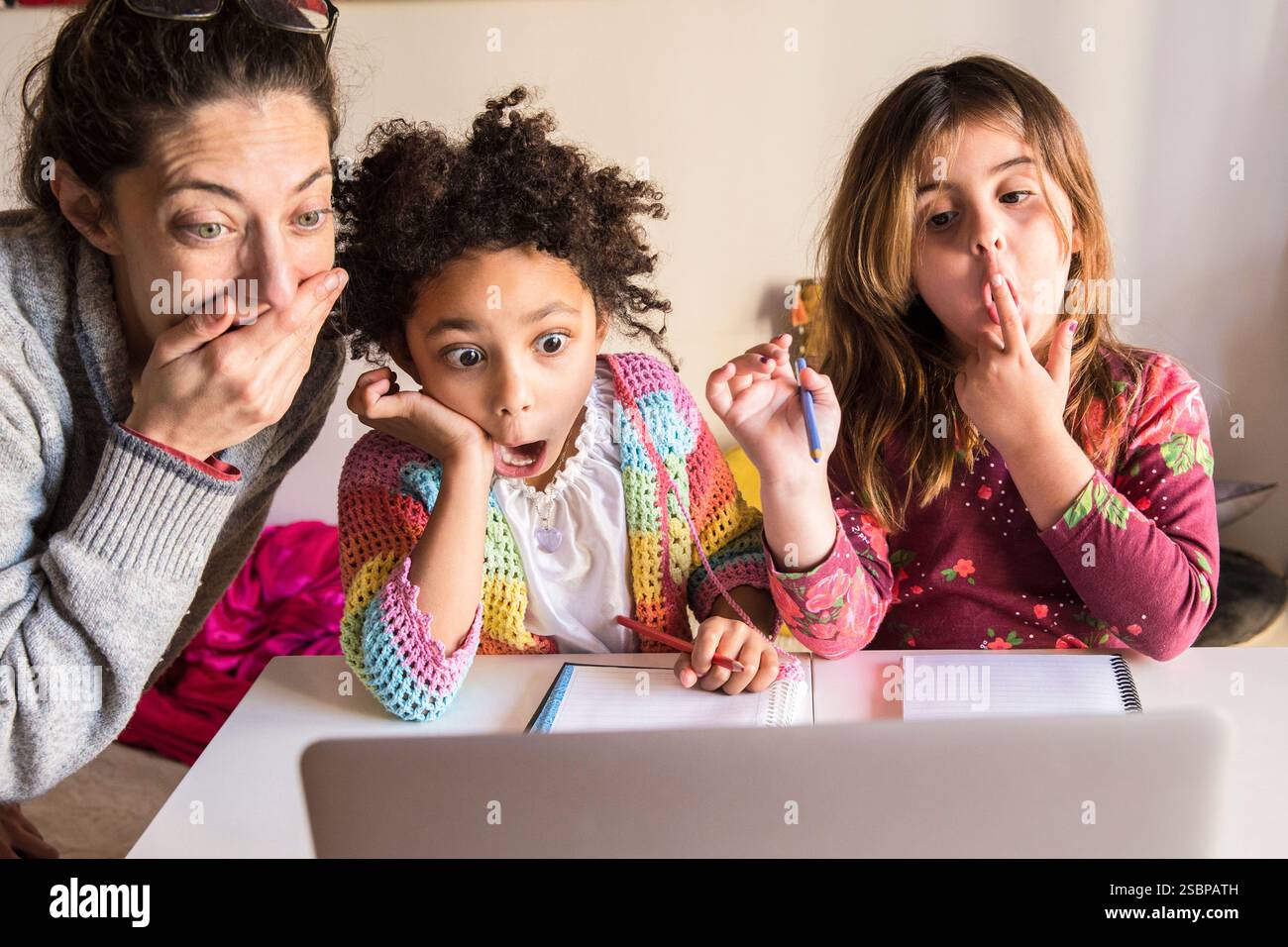 A mother and her two daughters share expressions of astonishment and ...