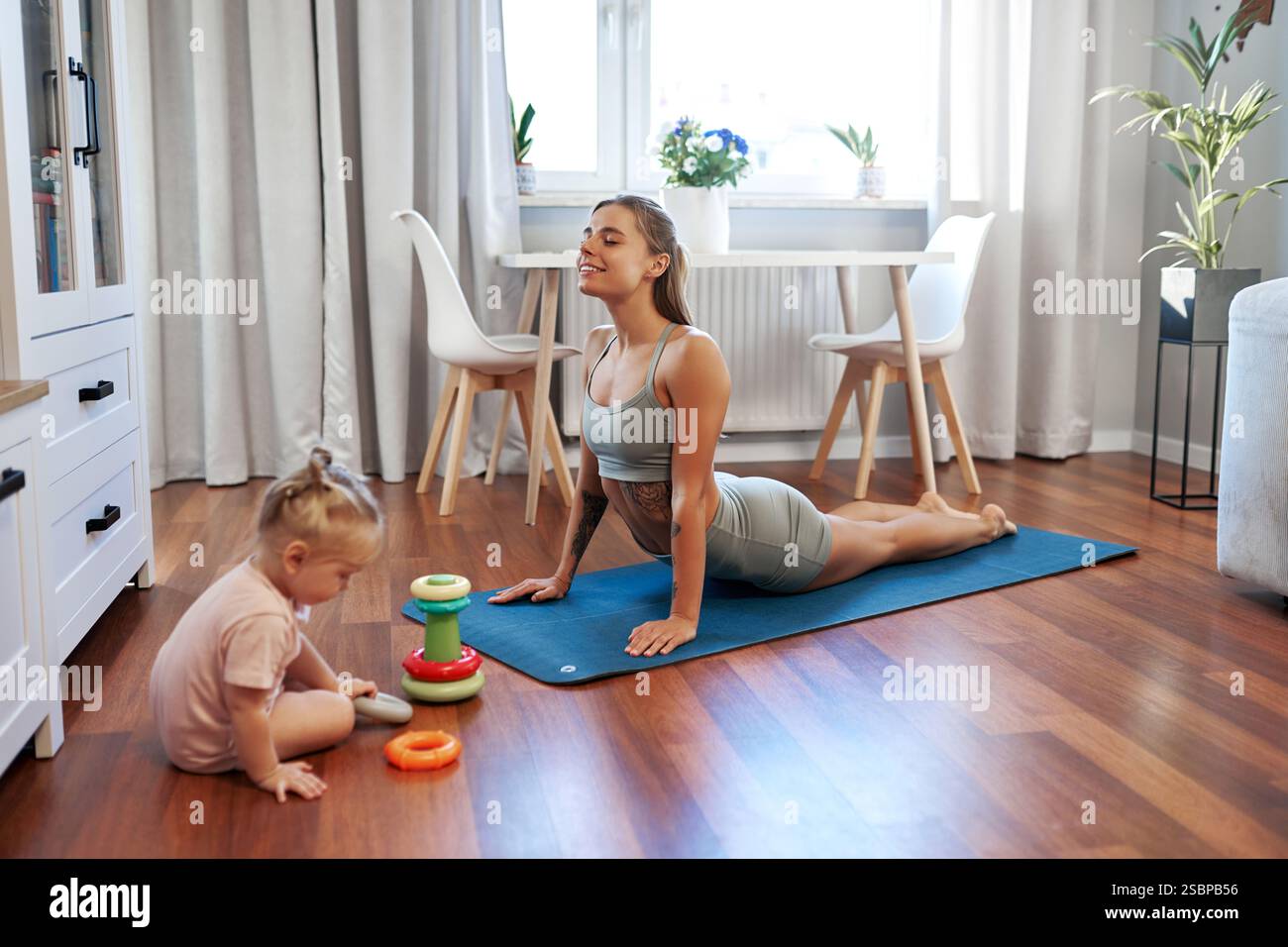 A devoted mother practices yoga while playfully engaging with her ...