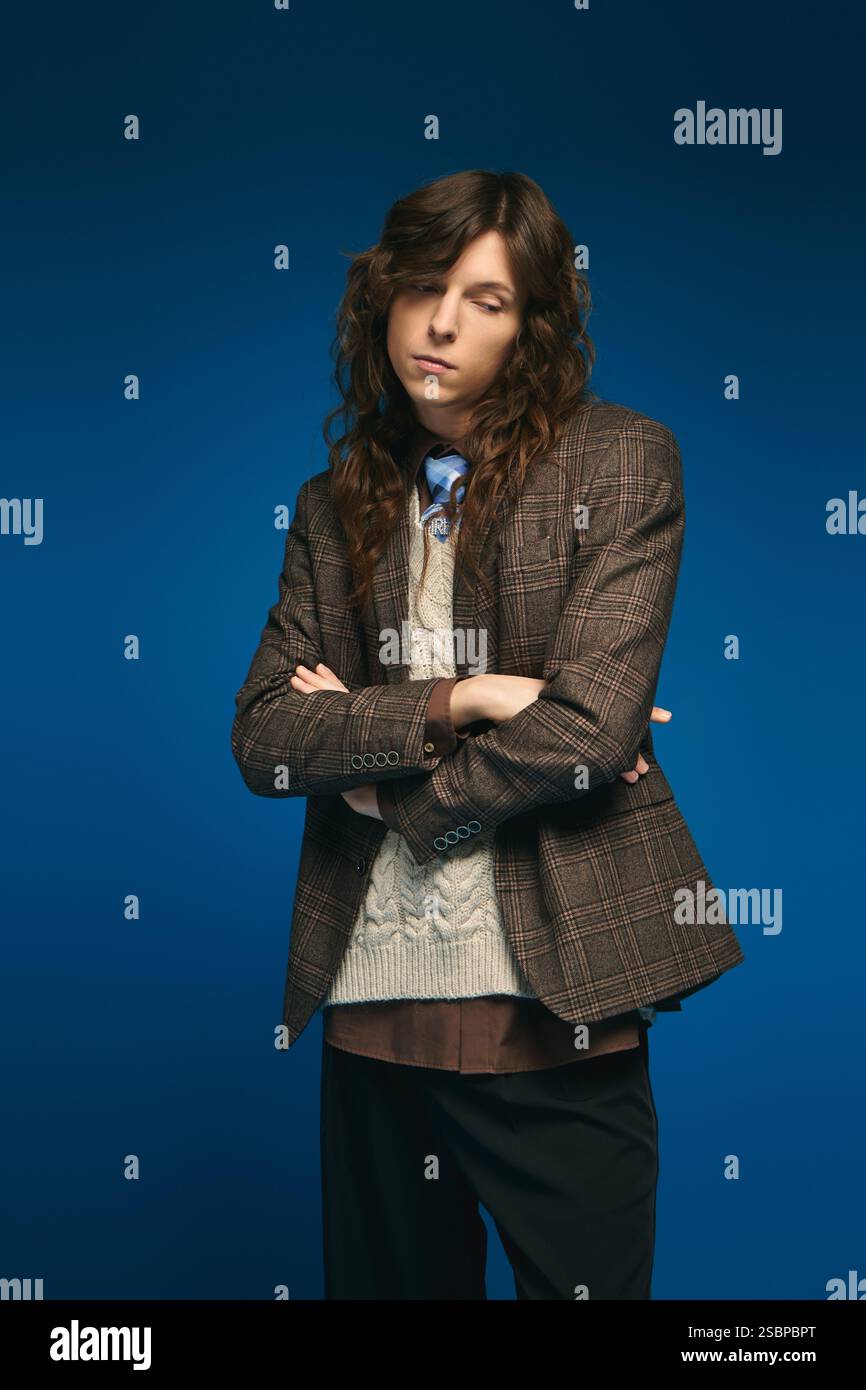 A young man showcases his chic style while dressed in a trendy ensemble ...