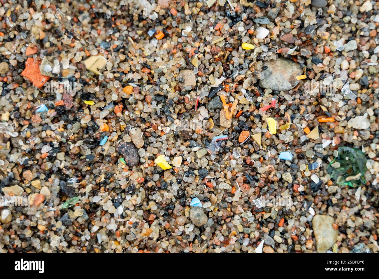 Close-up view of microplastic fragments scattered on beach, mixed with ...