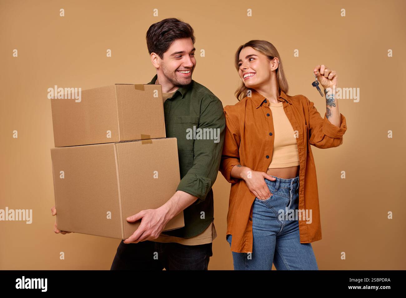 A joyful and happy young couple is celebrating their new home together ...