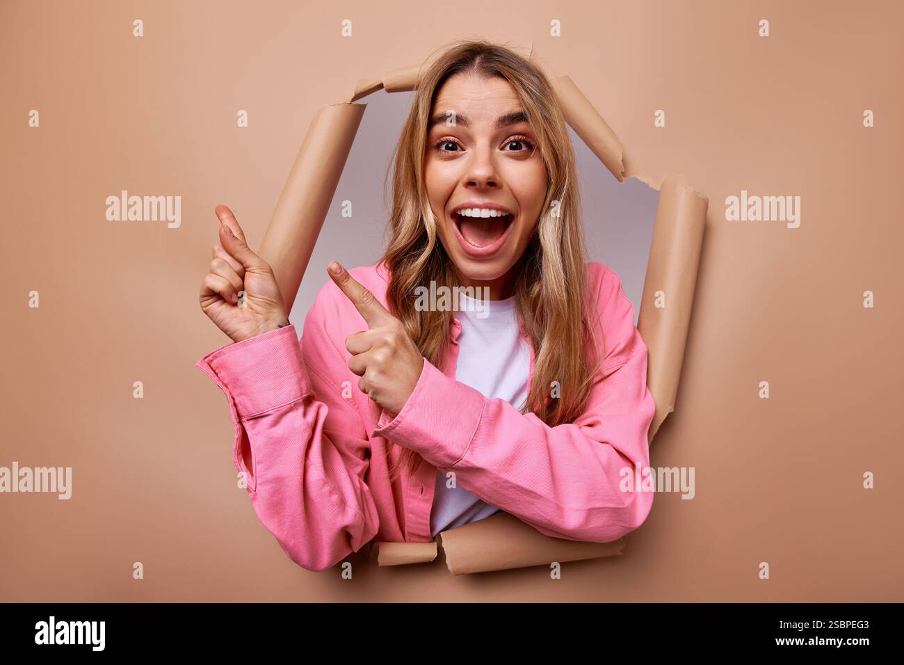 A cheerful young woman is joyfully expressing her excitement through ...