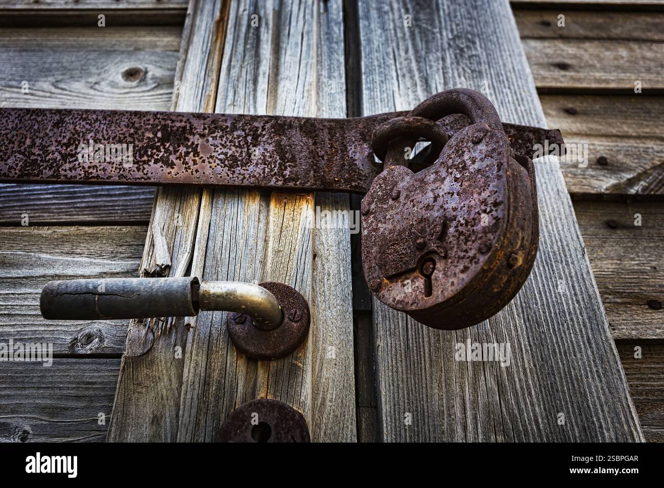 Old latch with padlock on gatees Stock Photo - Alamy