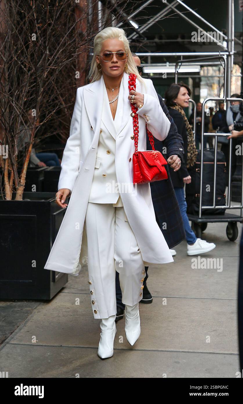 Singer Rita Ora wears a white pantsuit as she leaves a downtown hotel ...