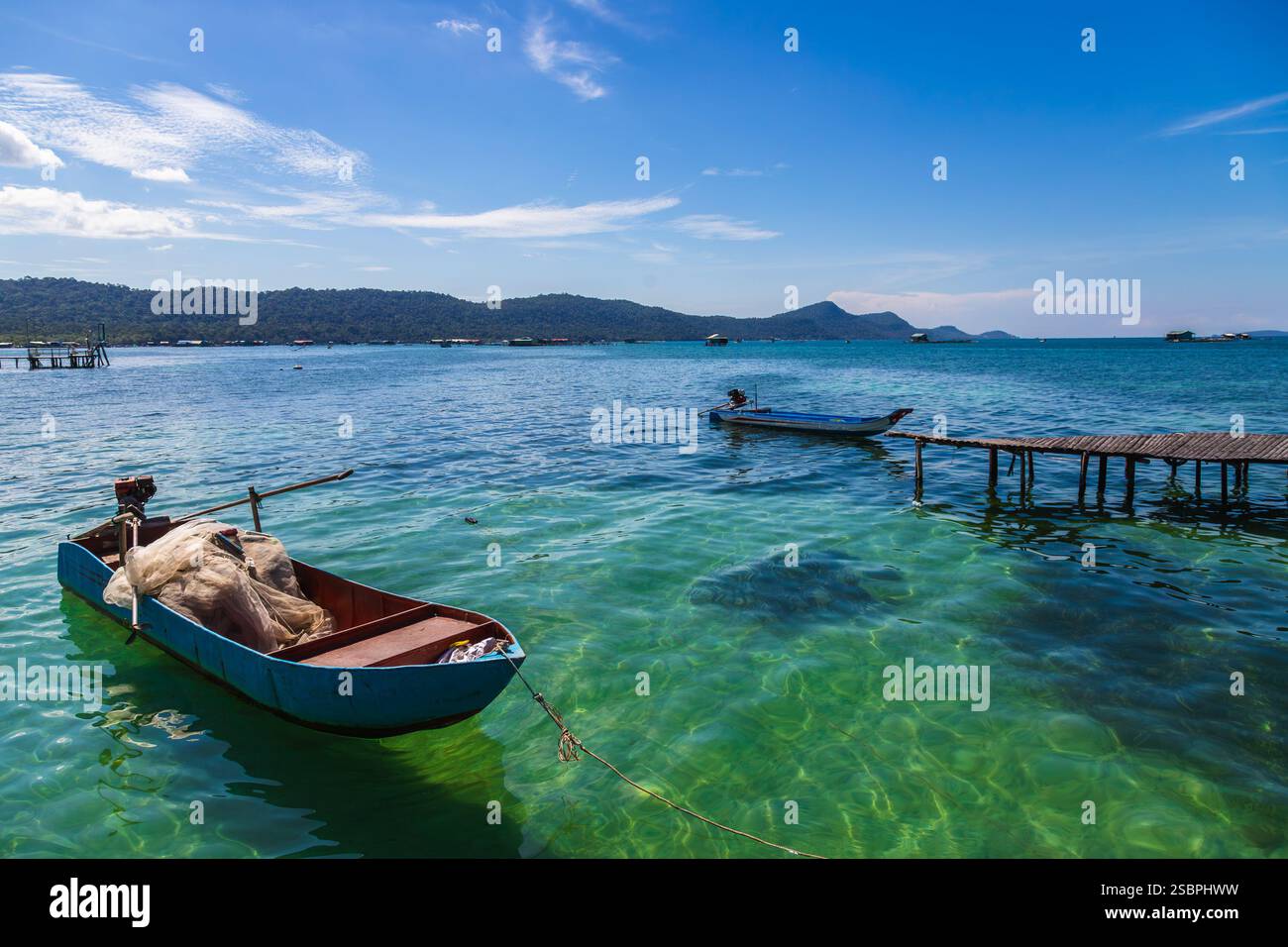 coastal scene with a curved wooden pier extending into the clear ...