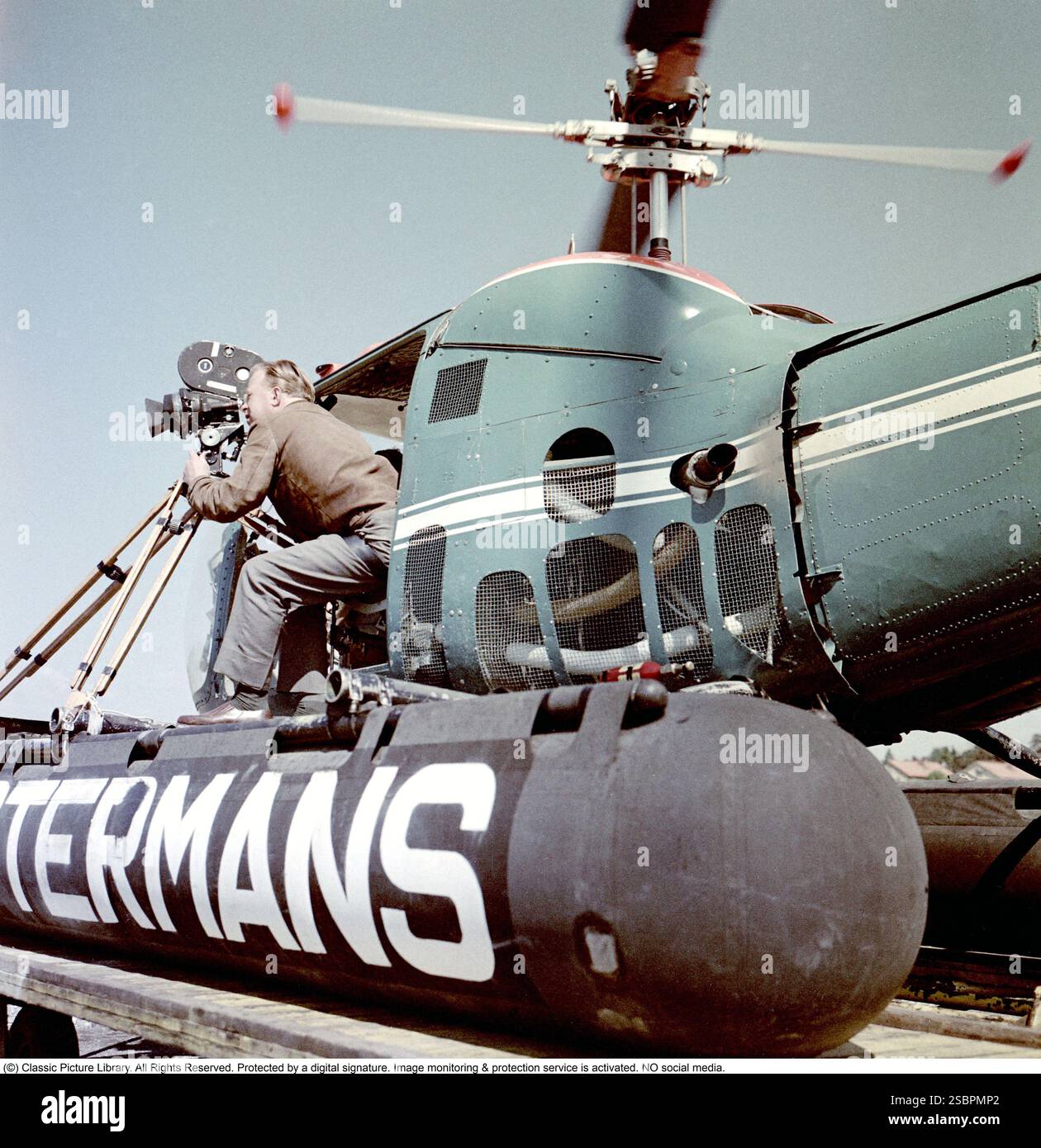 Filming in the 1950s. A cinematographer is standing half way out of a ...