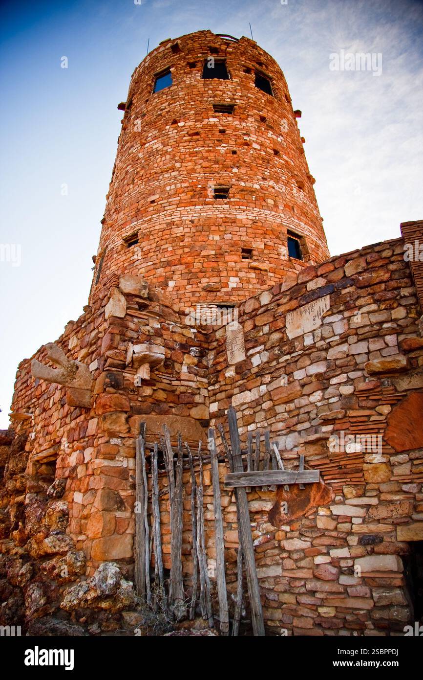 A tall brick tower with a gate on the side. The gate is rusted and the ...
