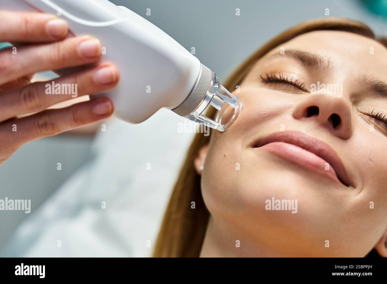 A young woman enjoys a dermatology procedure that enhances her natural ...