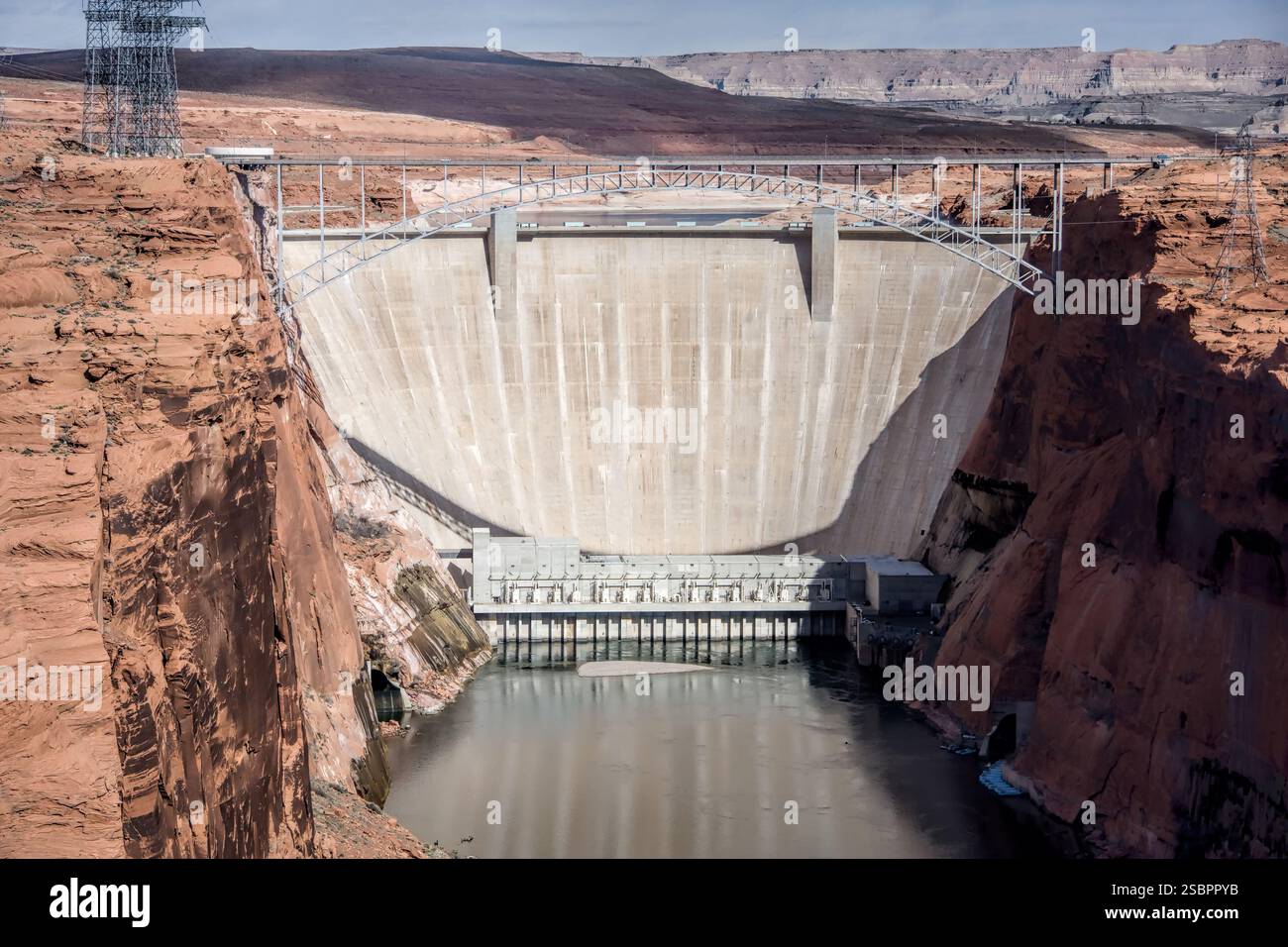 A large dam is built on a river. The dam is made of concrete and is ...
