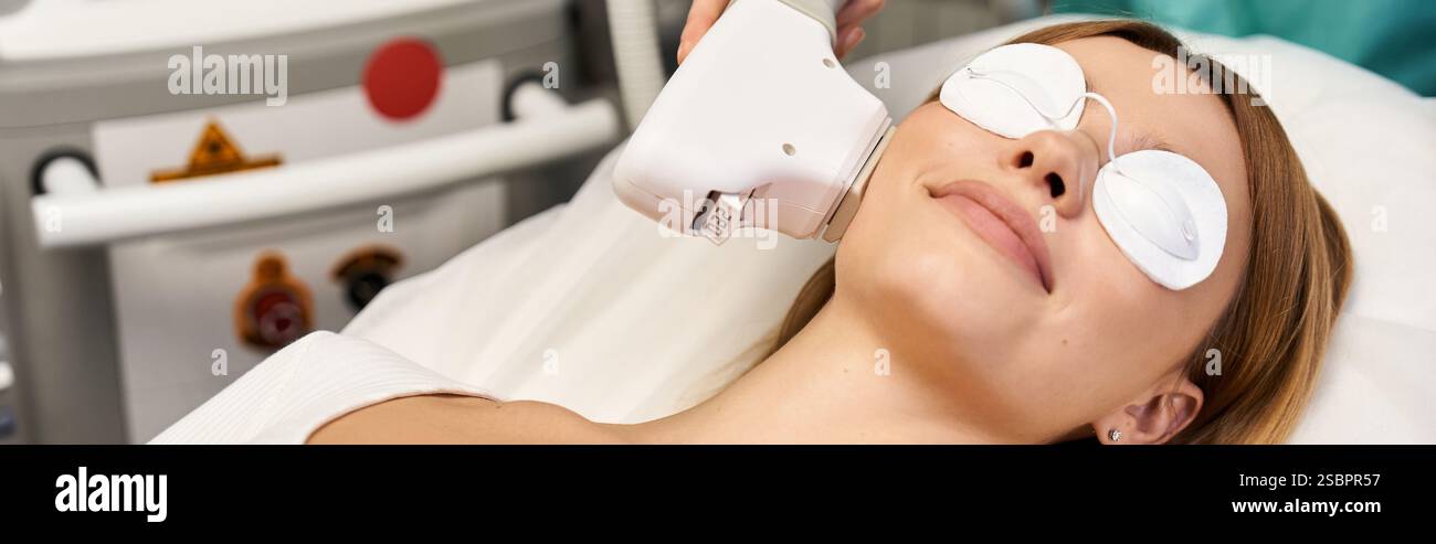 A beautiful young patient enjoys a dermatology procedure with ...