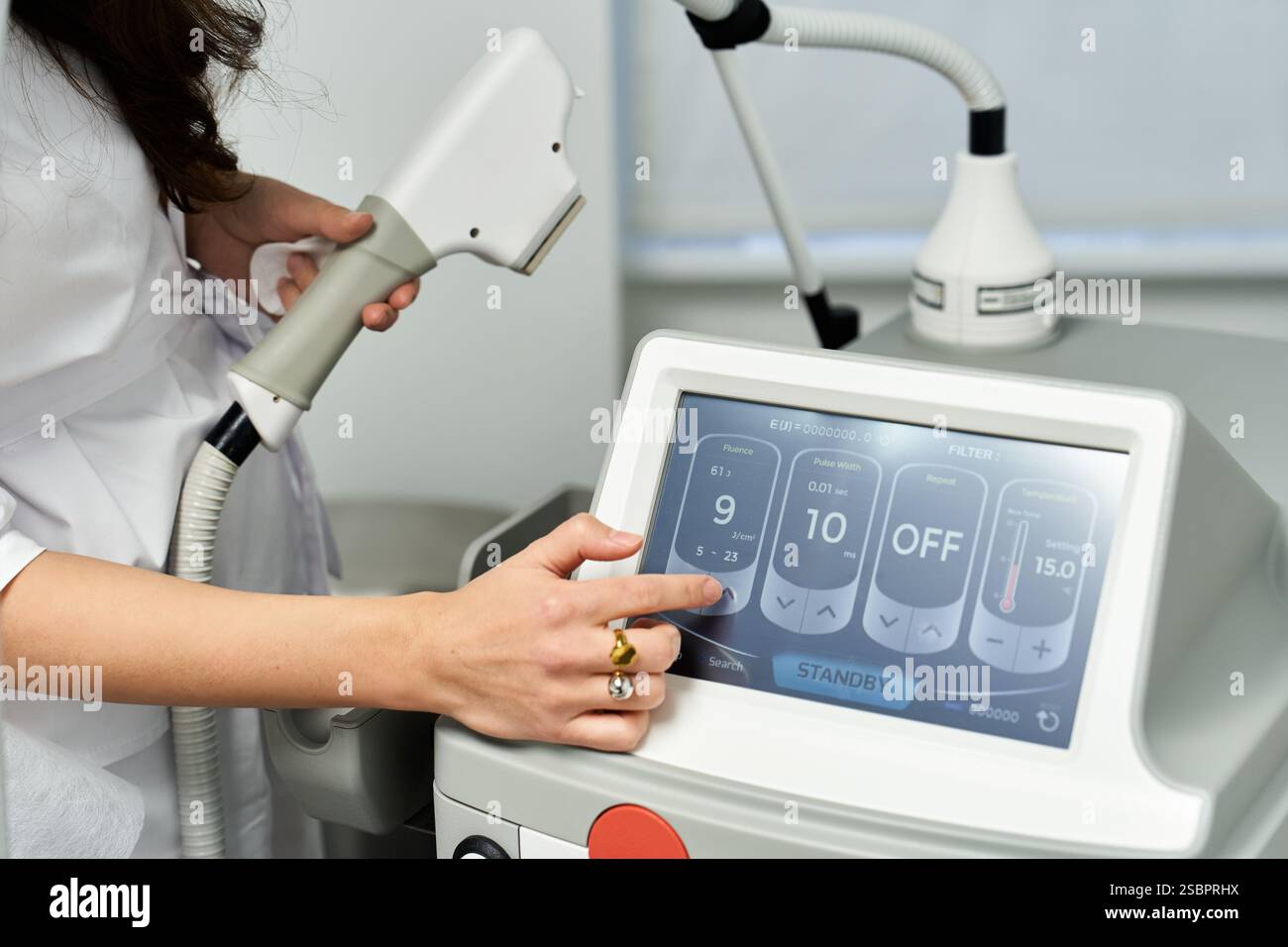 Young dermatologist performs a skin procedure using high tech equipment ...