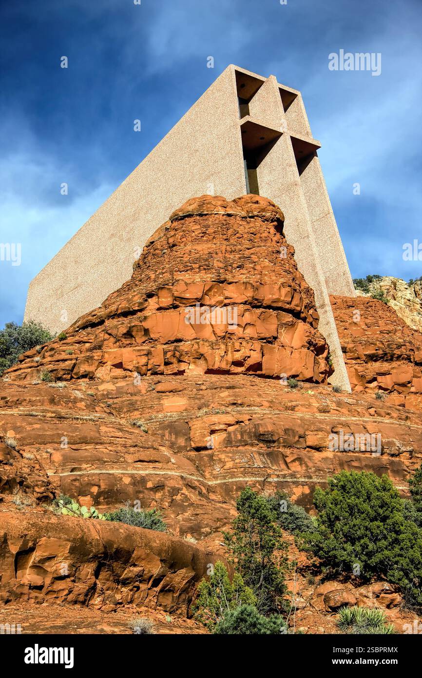 A large rock formation with a cross on top. The cross is on a building ...