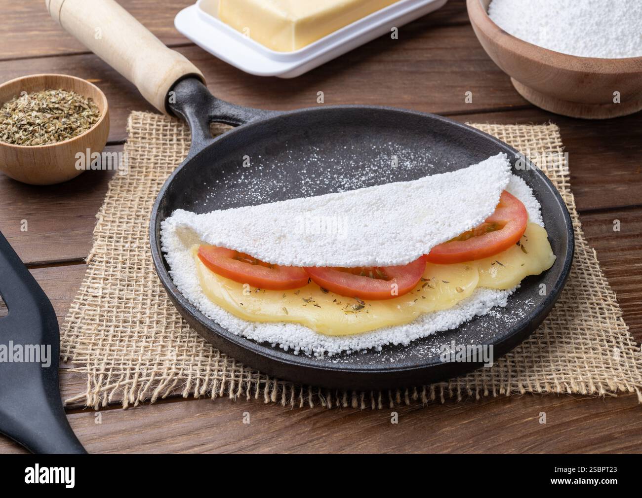 Traditional brazilian cheese and tomato stuffed tapioca on a pan with ...