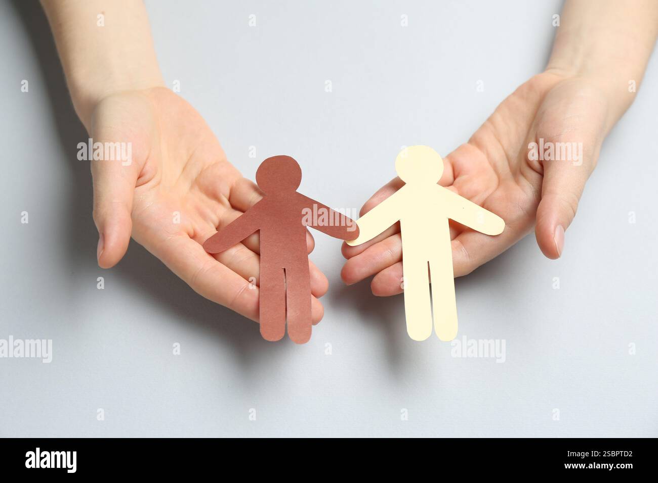 Stop racism. Woman holding human paper figures of different colors on ...