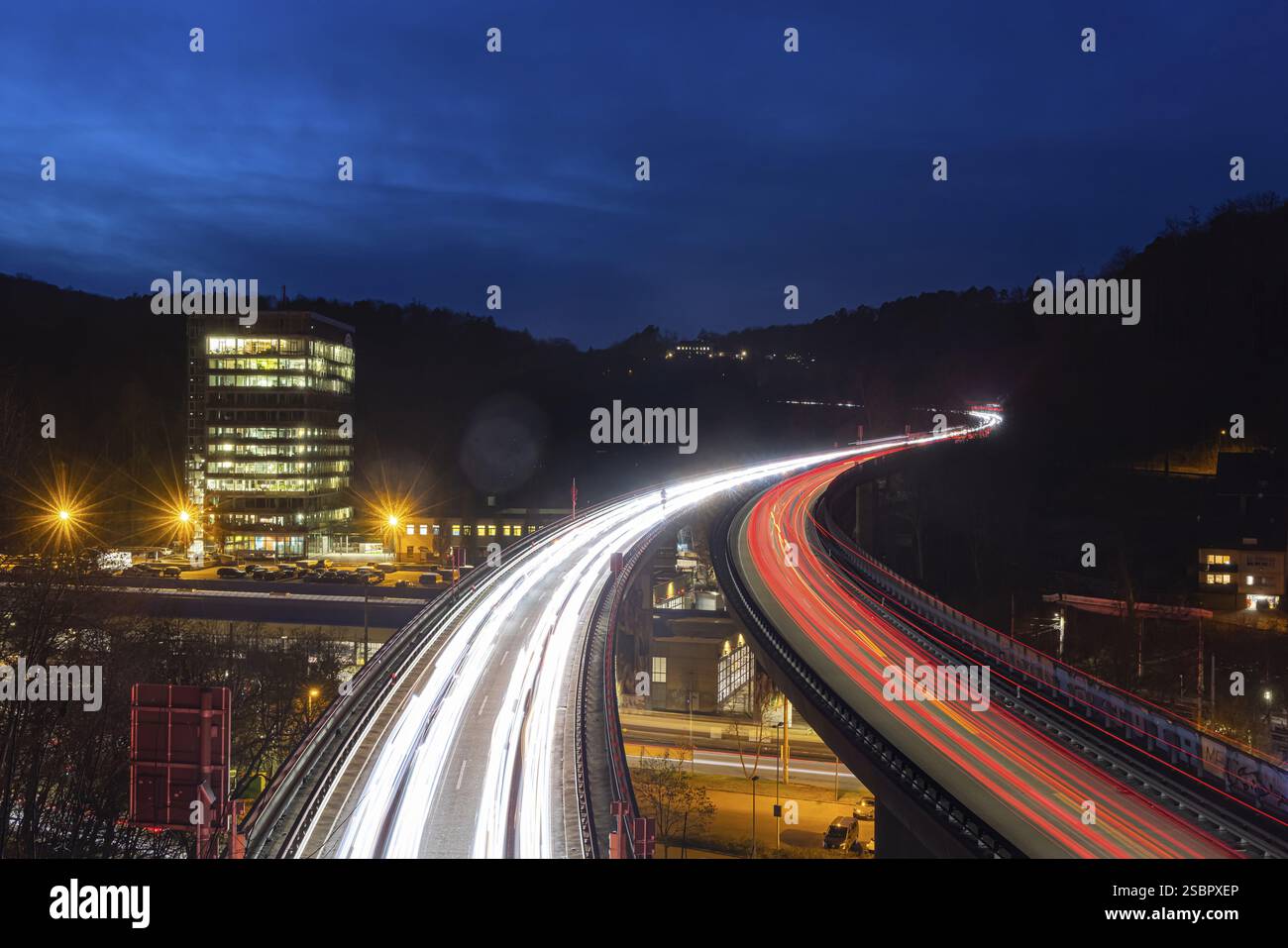 Federal road B14 at night, road bridge with traffic and light lanes. On the left the building of ...