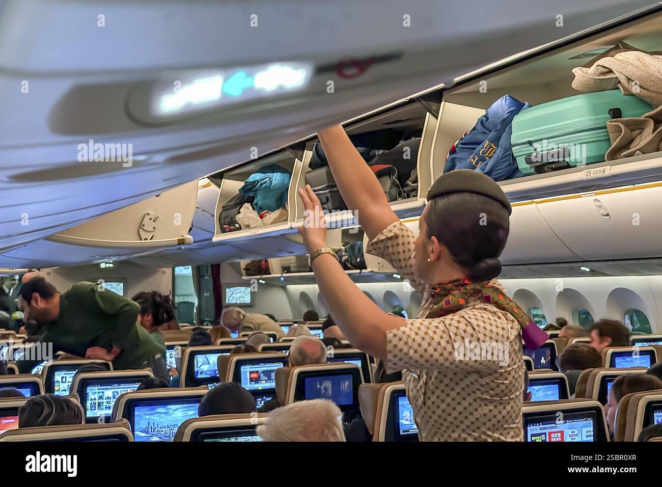 Etihad airline aircraft, interior, rows of seats with passengers ...