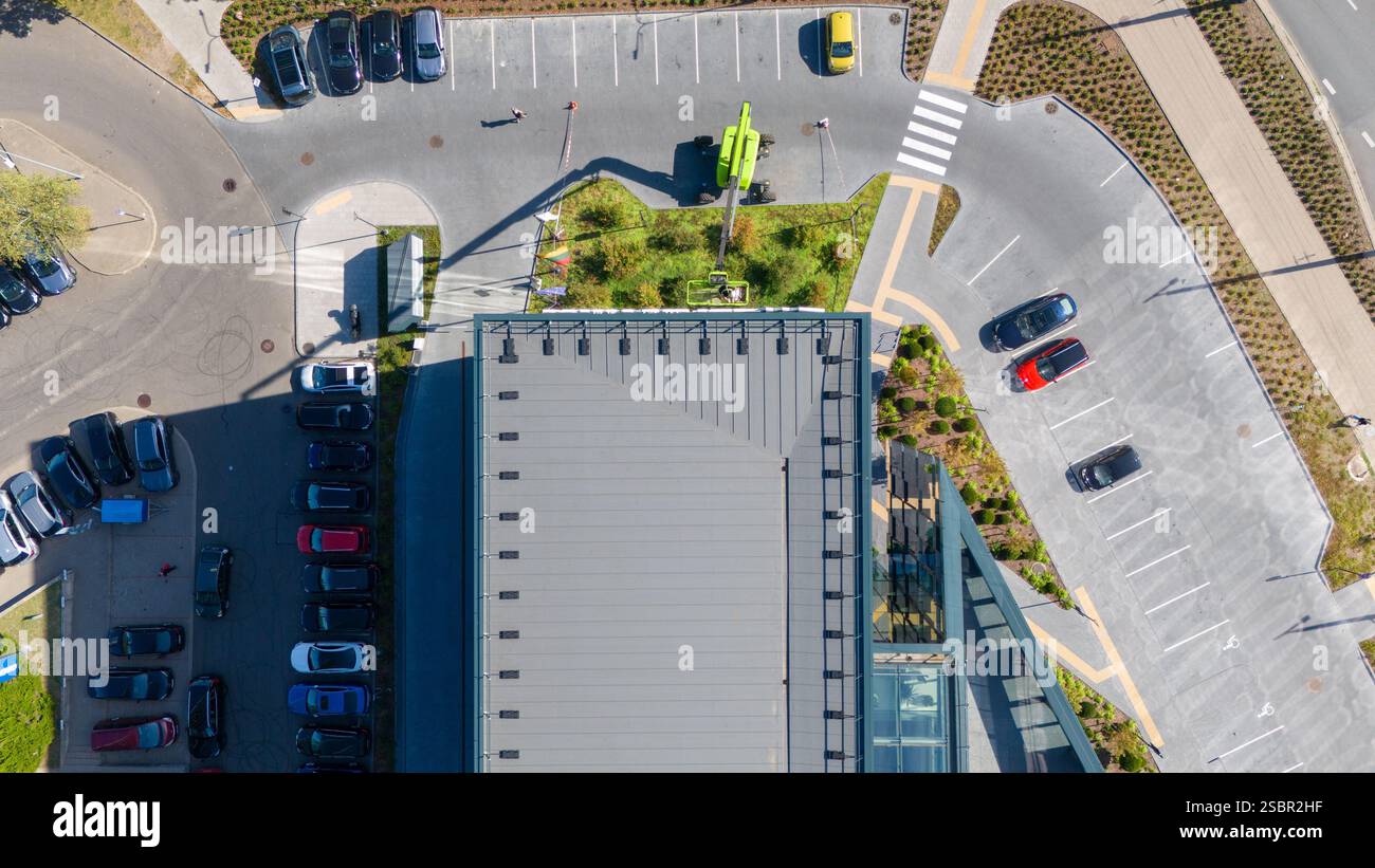 Aerial view of a parking lot with multiple cars parked around a modern ...