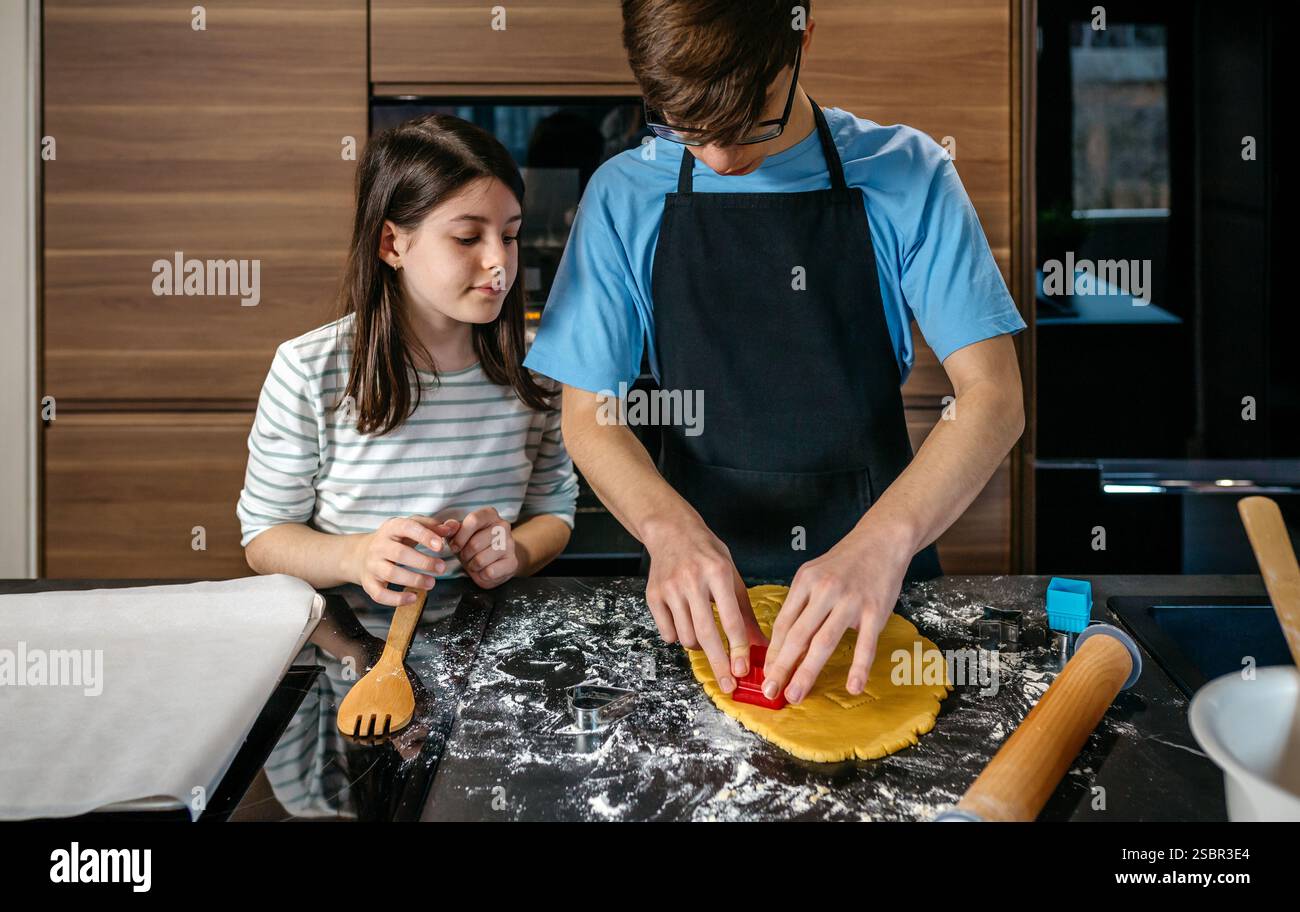 Brother and sister making cookies together for a party at home Stock ...