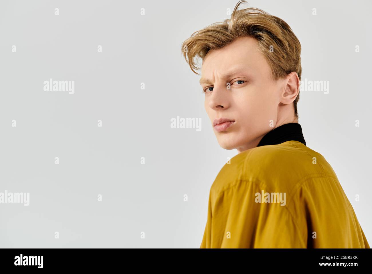 Young man with striking features looks back confidently, showcasing his ...