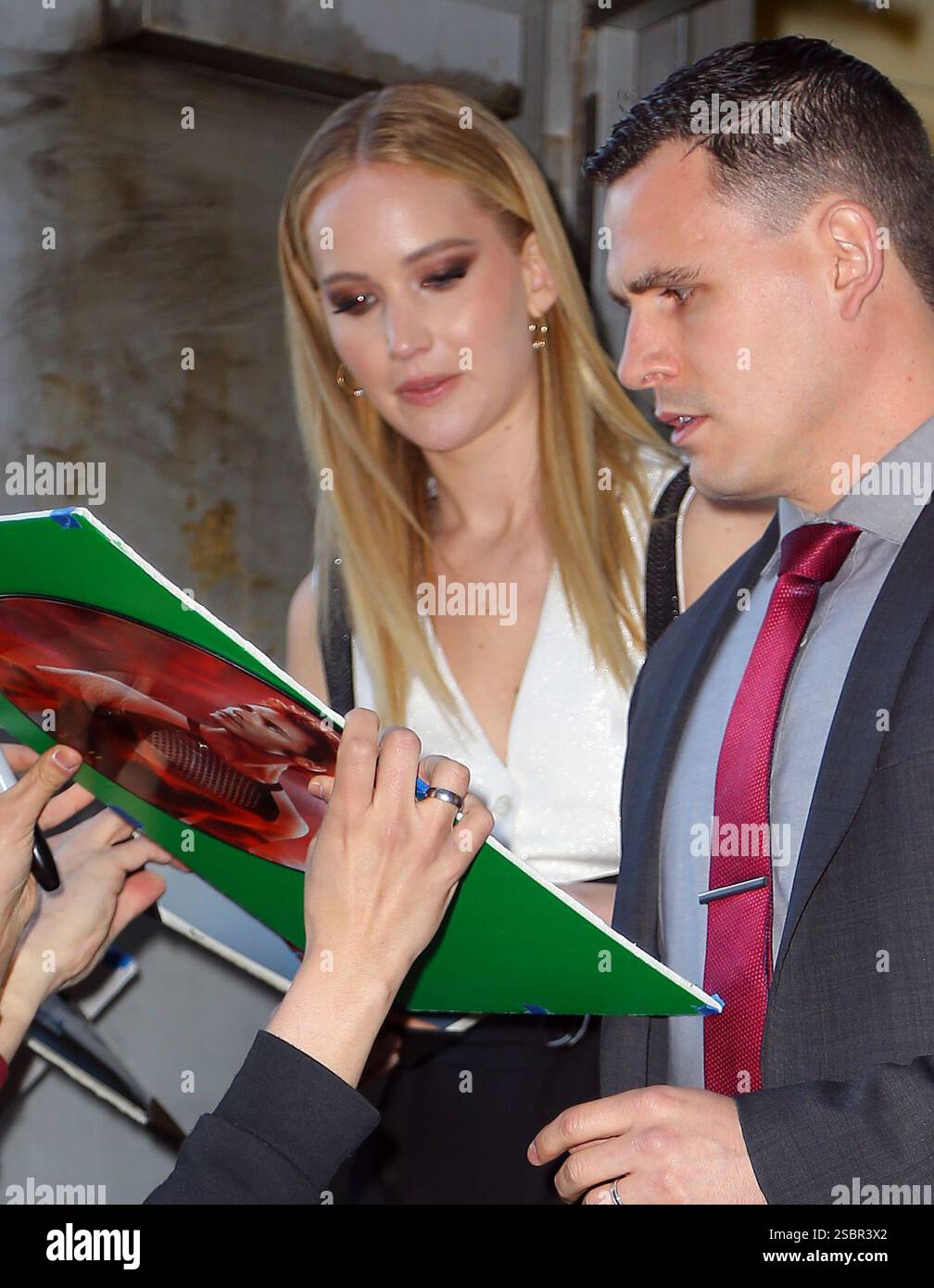 Actress Jennifer Lawrence signs autographs for fans as she leaves a ...