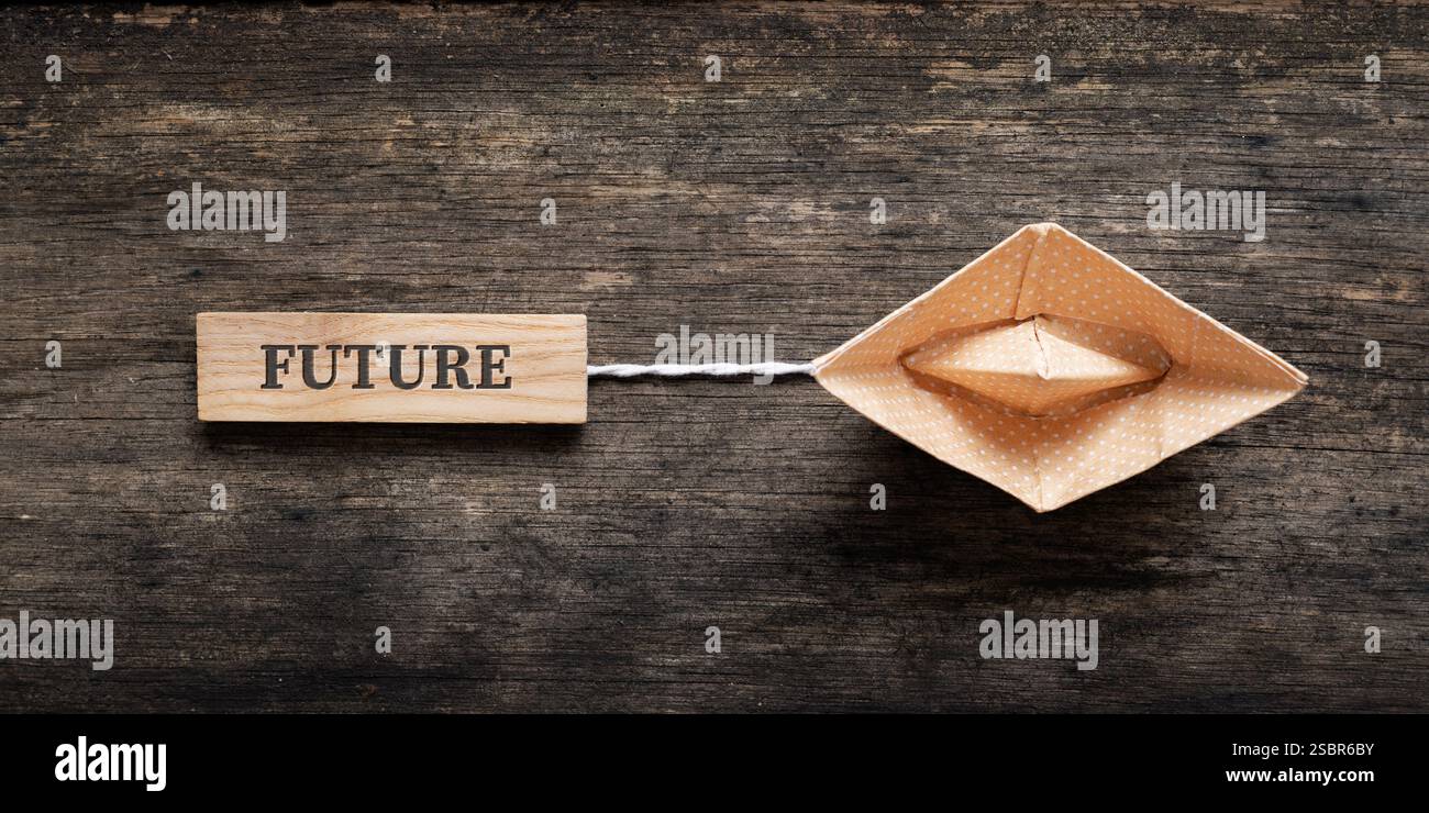 A paper boat tied to a wooden block labeled FUTURE symbolizes progress ...