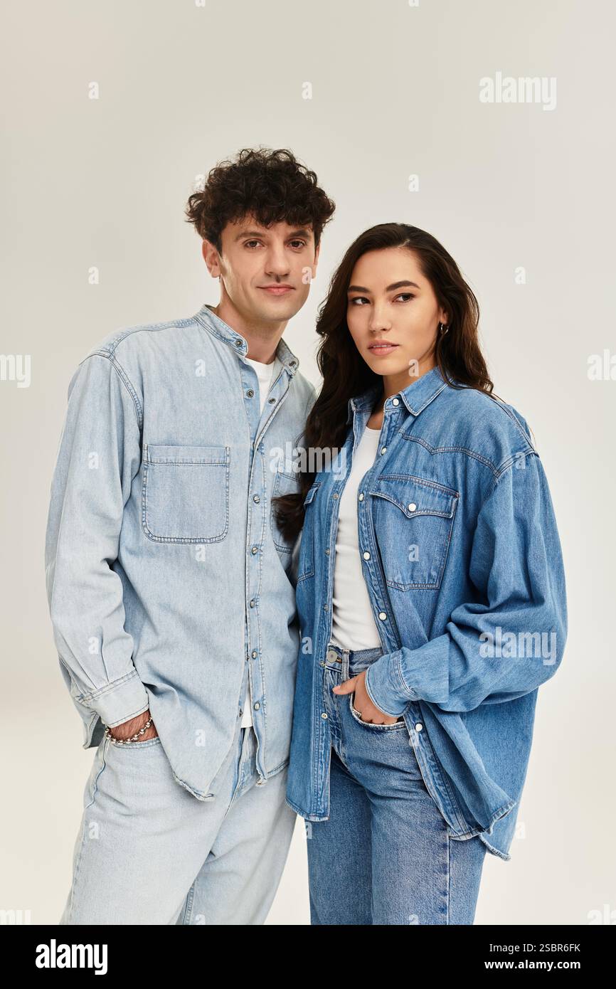 Fashionable young couple poses together in matching denim outfits ...