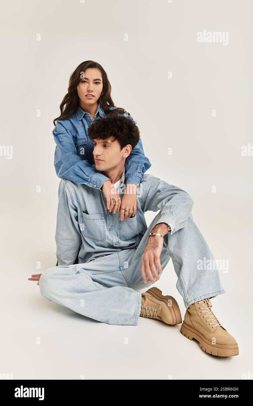 Confident young couple in matching denim outfits poses stylishly ...