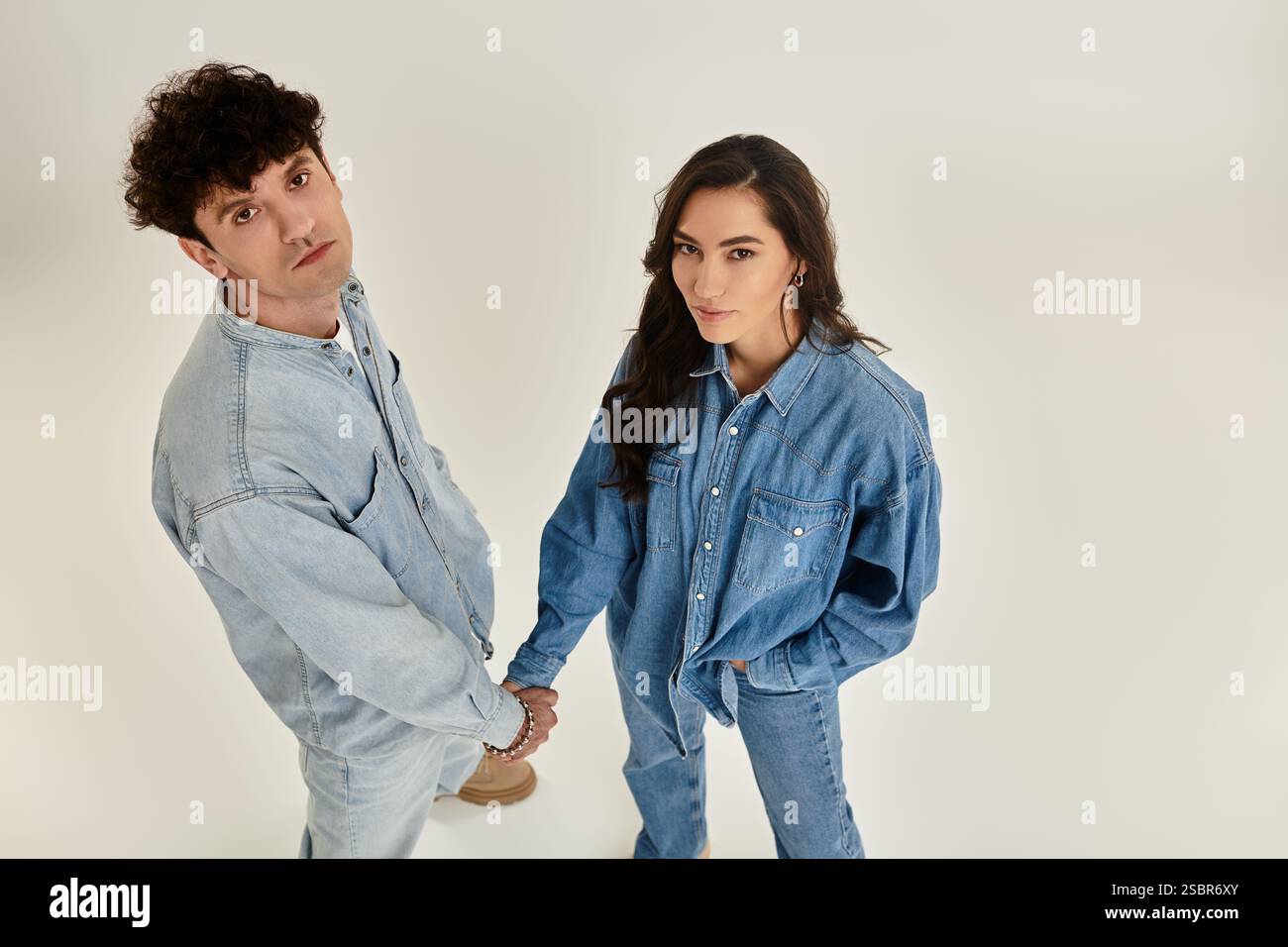 Stylish young couple poses confidently in matching denim outfits with a ...