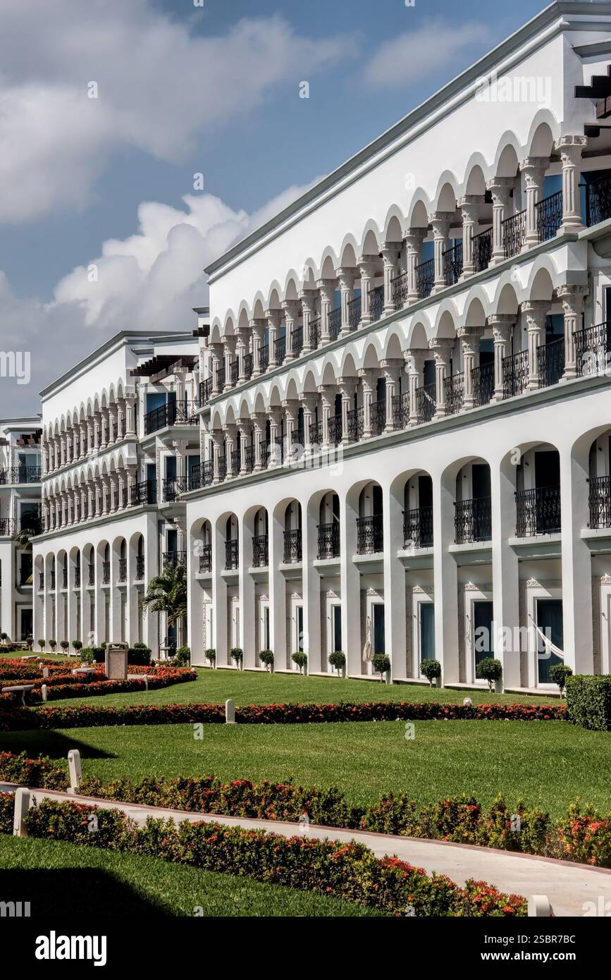 A large white building with a green courtyard in front. The building ...