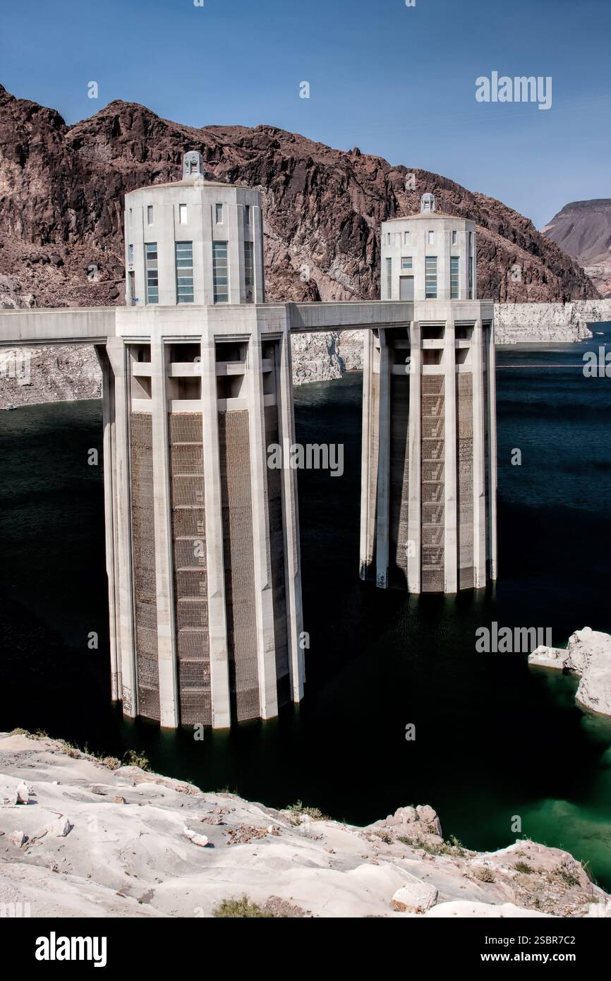 Two tall concrete towers are in the water. The water is green Stock ...